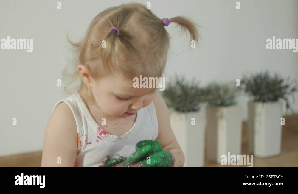 Closeup of a little girl, dirty in multicolored paints. The child ...