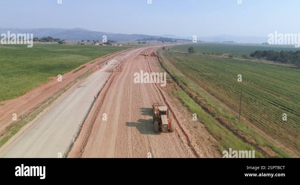 Rural construction of road through fields in third world setting aerial ...