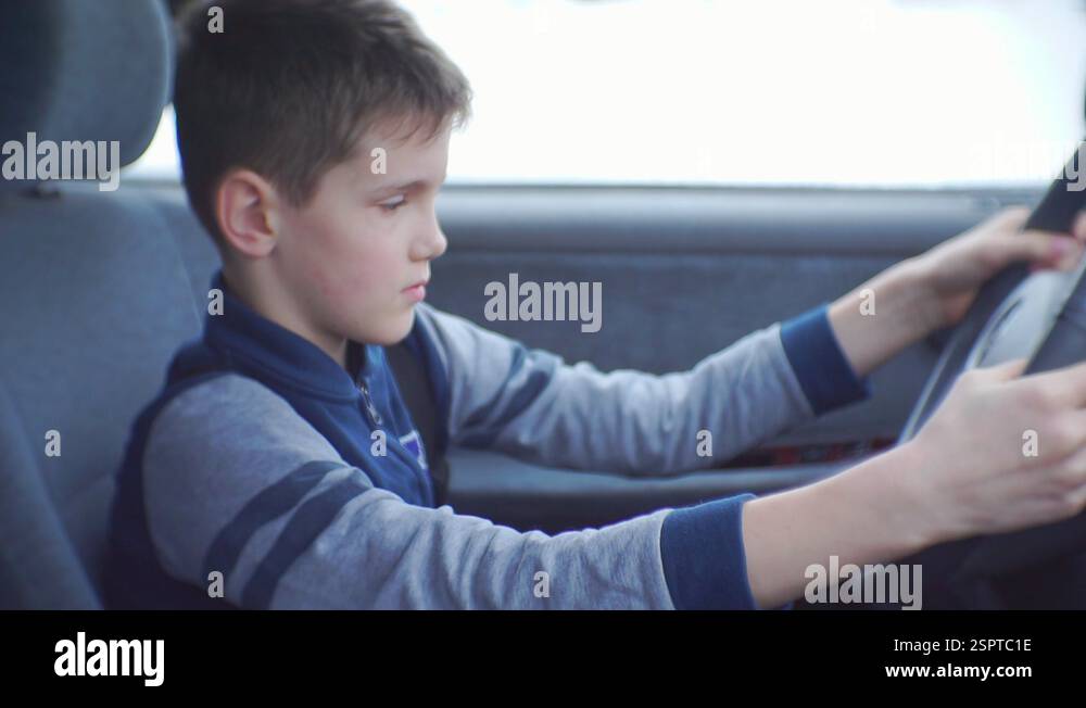 boy sitting behind the wheel inside the car Stock Video Footage - Alamy