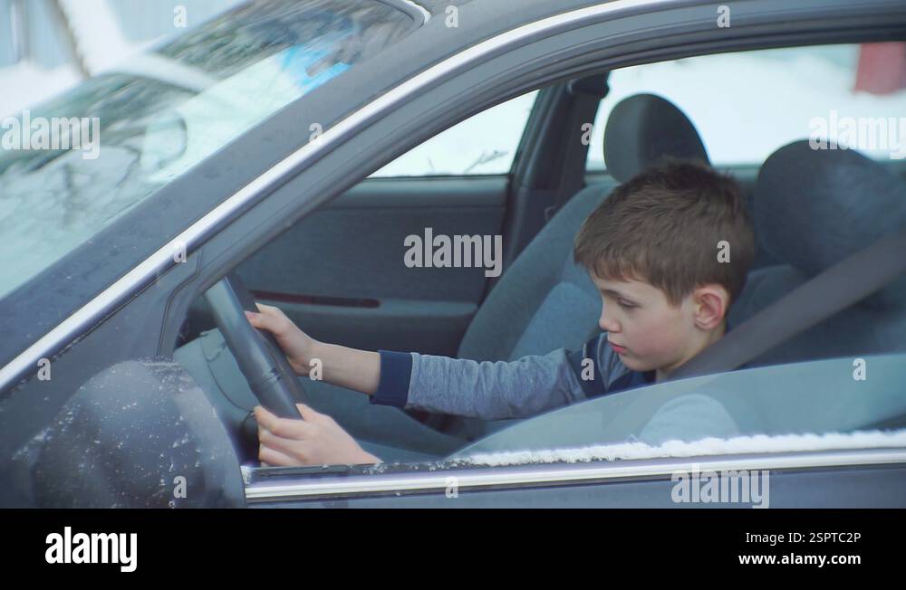 boy sitting behind the wheel inside the car Stock Video Footage - Alamy