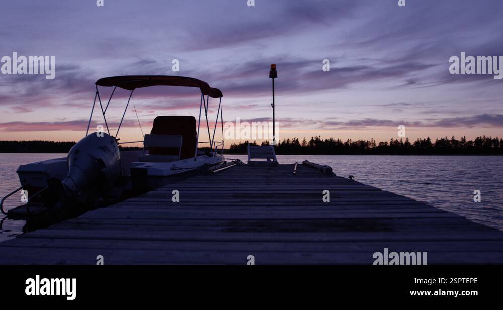 small boat docked at dusk on personal wharf - slow dolly shot towards ...
