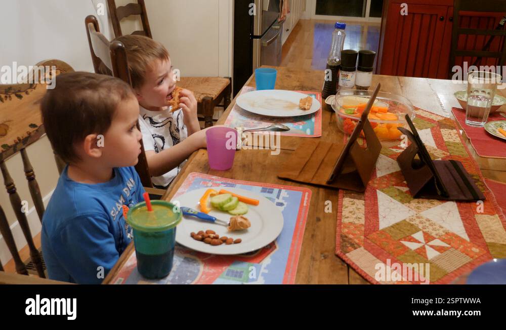 Family watching tablets while eating at the table Stock Video Footage ...
