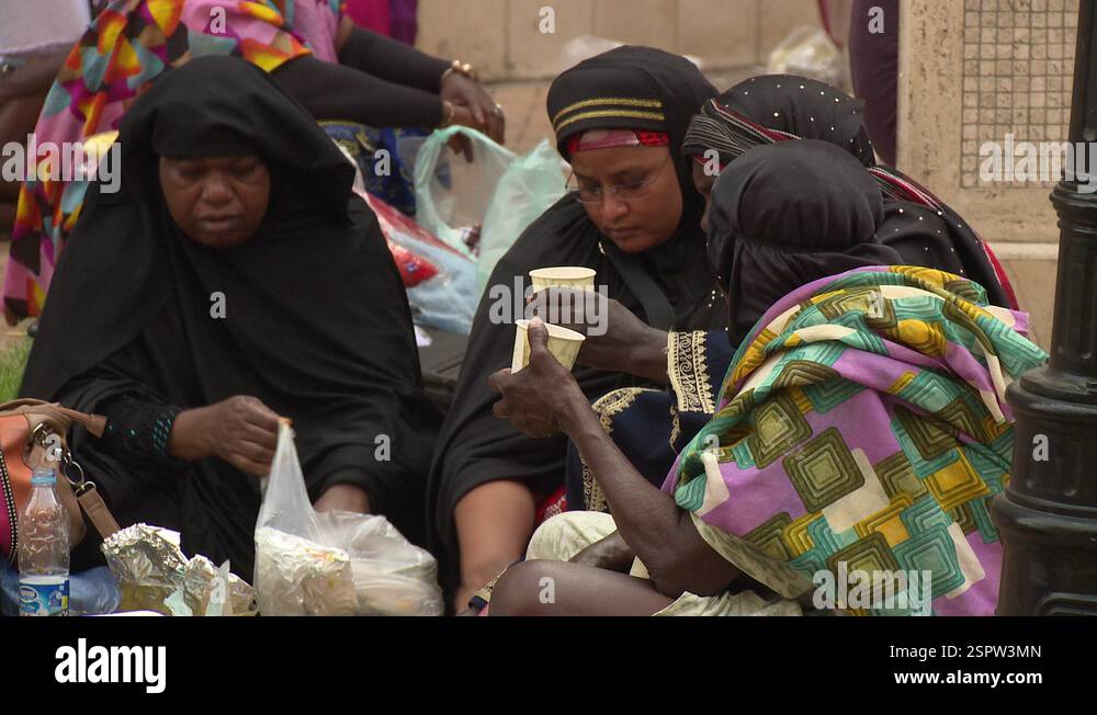 Three Muslim women talking, eating in plaza in Medina, Saudi Arabia ...