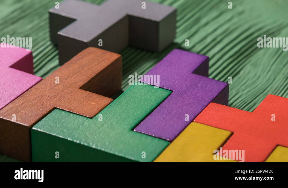 Close up of colorful wooden blocks folding on the green table ...
