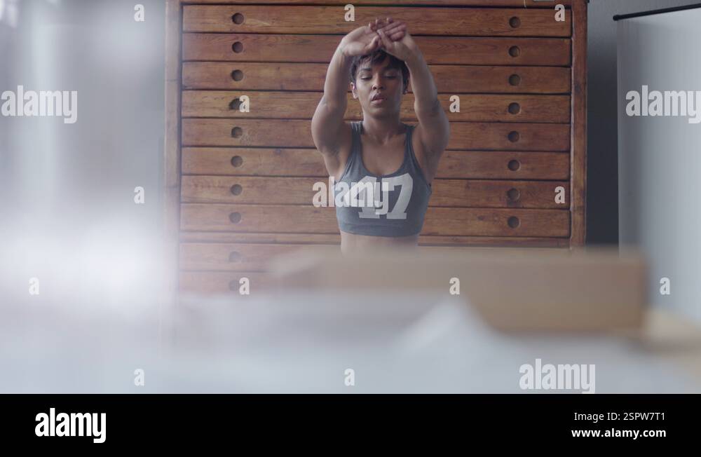 young fit and tone up woman doing stretching routine in sunny loft ...