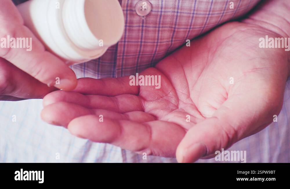 treatment with tablets.hand takes the tablets from the bottle into the ...