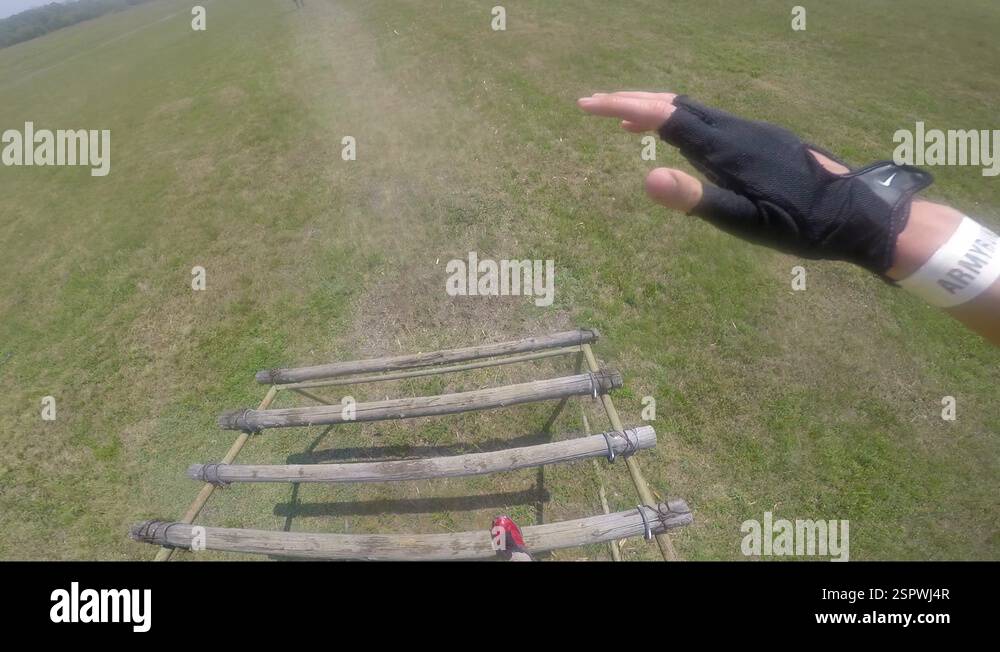POV - a man climbs over a wooden obstacle and runs on at a race Stock ...