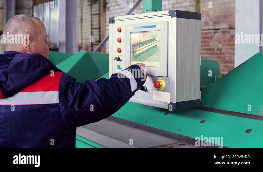 Man working at programmable machine. Sheet metal bending. Focus on ...