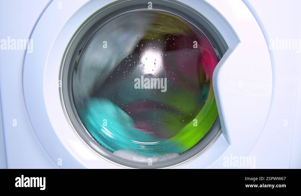 Washing machine washes colored clothing and sheets. Cylinder spinning ...