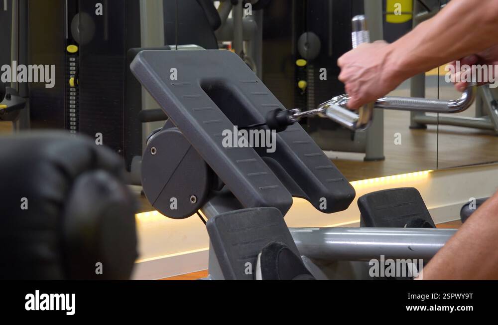 A fit man trains on a rowing machine in a gym - closeup Stock Video ...