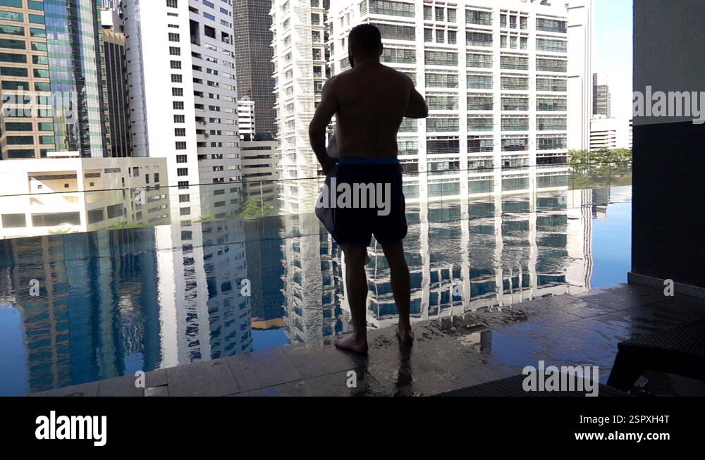 Silhouette of man drying his body by swimming pool, super slow motion ...