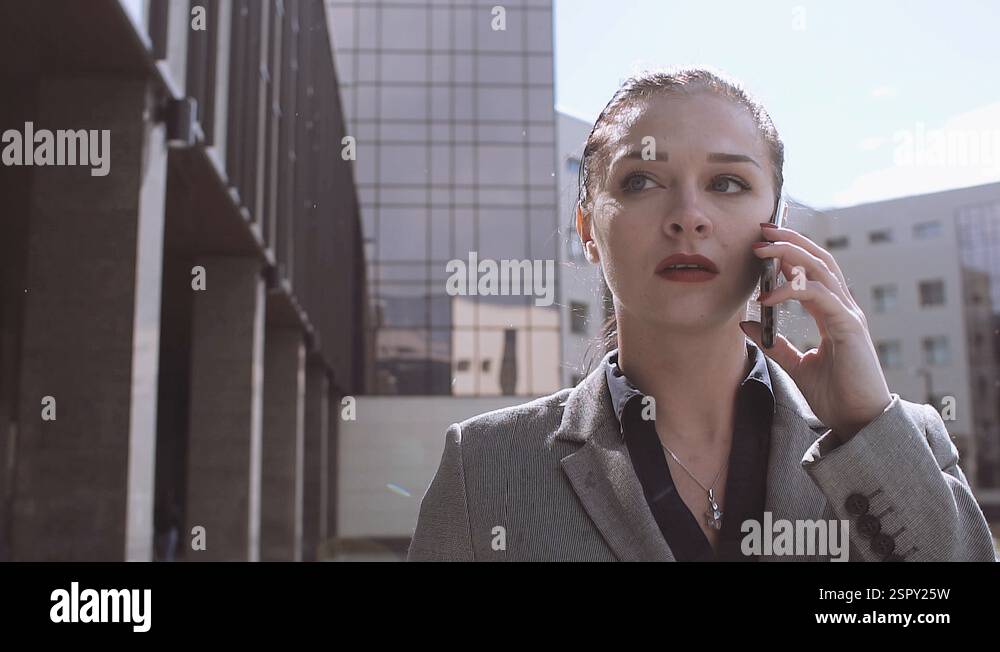 A business woman with beautiful expressive eyes goes and talks on the ...
