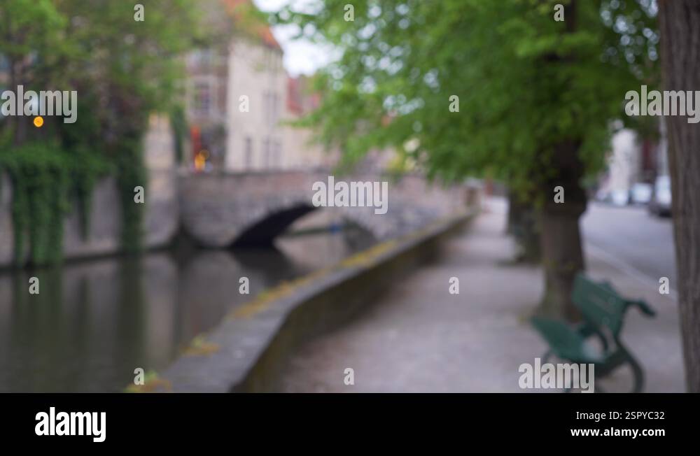 Out of focus video background pate of Bruges canal and public bench on ...