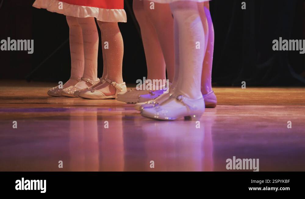 Legs of small artists shod in dance shoes on the stage during the ...