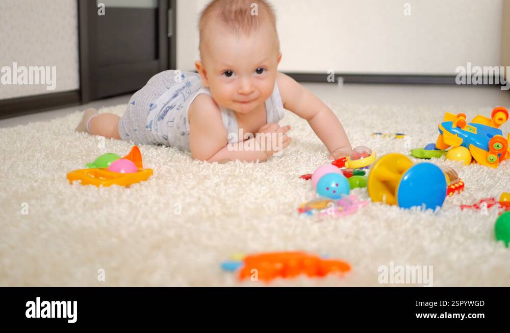 Little baby boy of seven months, crawling on the floor at children room ...