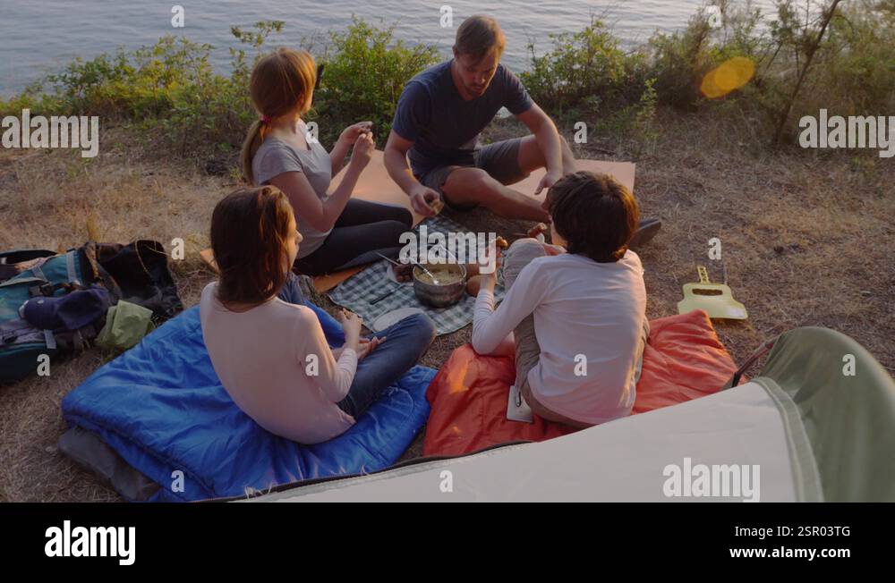 a happy family of tourists, eating camp food, next to a tent Stock ...