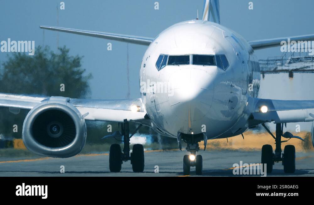Plane taxiing along the taxiway before takeoff. Aircraft maneuvers the ...