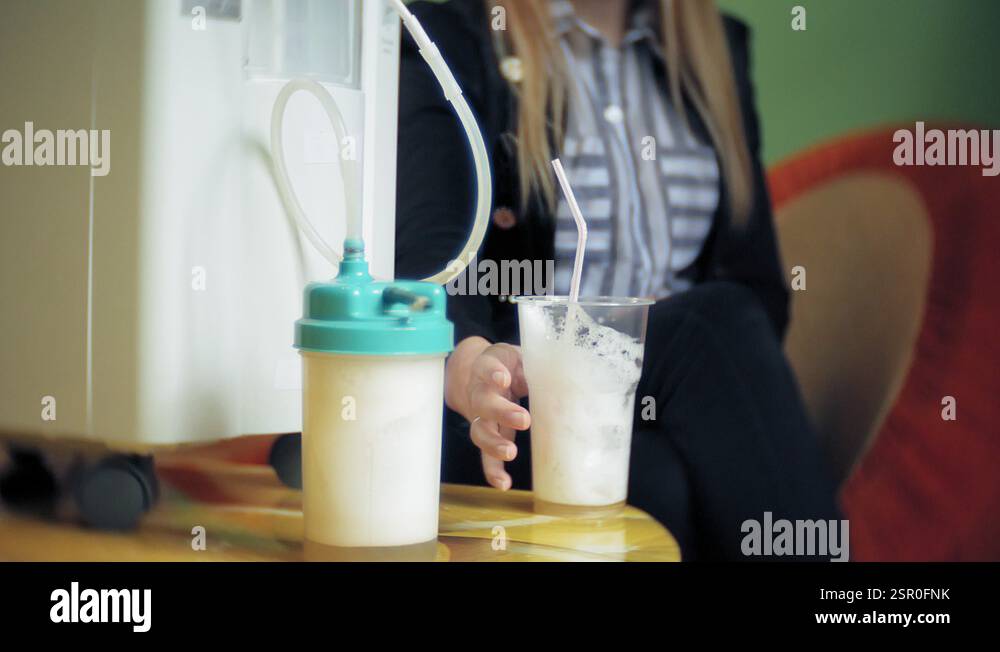 A woman drinks an oxygen cocktail with a device for oxygen scum. Oxygen ...
