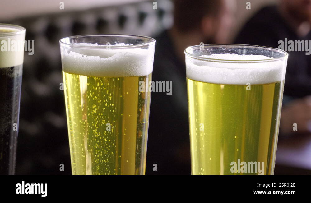 Three glasses of beer standing on the bar counter in a modern ...