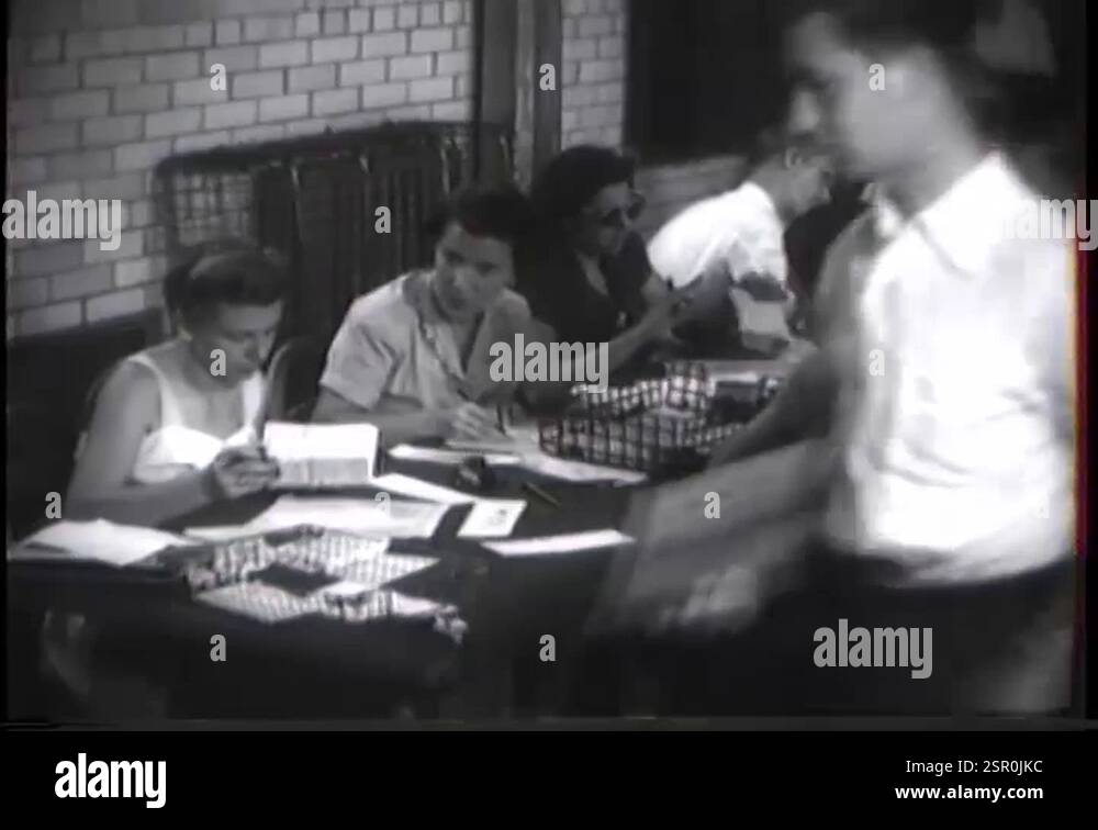 Men seat at table while the women fill out form and talks with them - 1948 Stock Video Footage ...