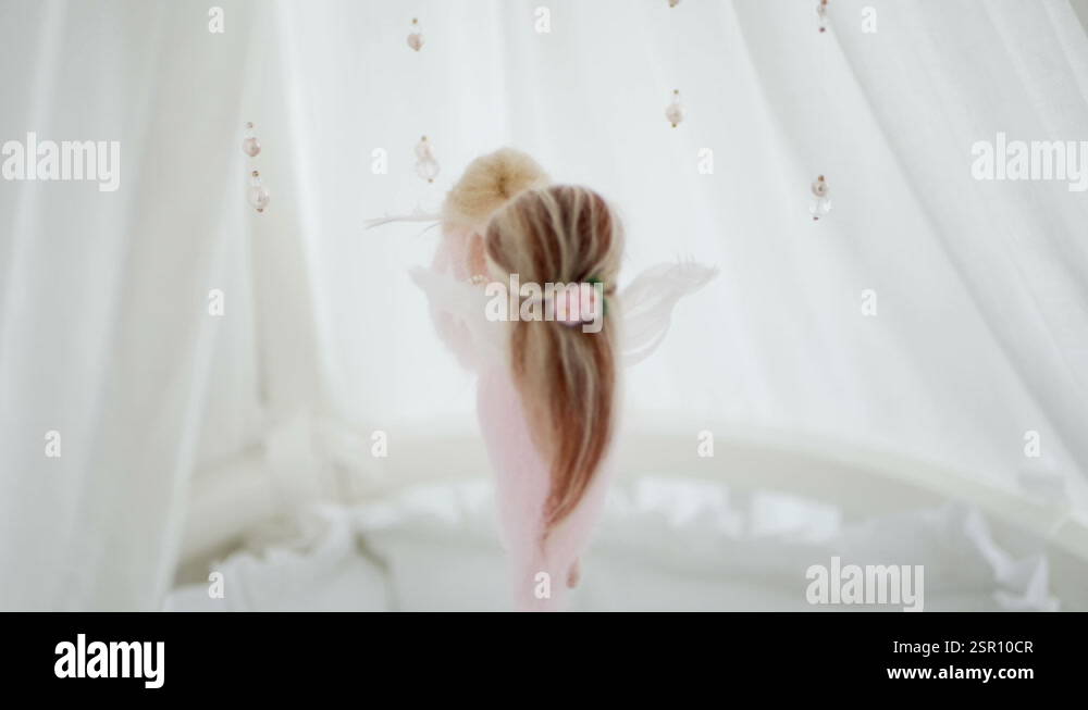 two toy knitted girl whirling over baby cot Stock Video Footage - Alamy