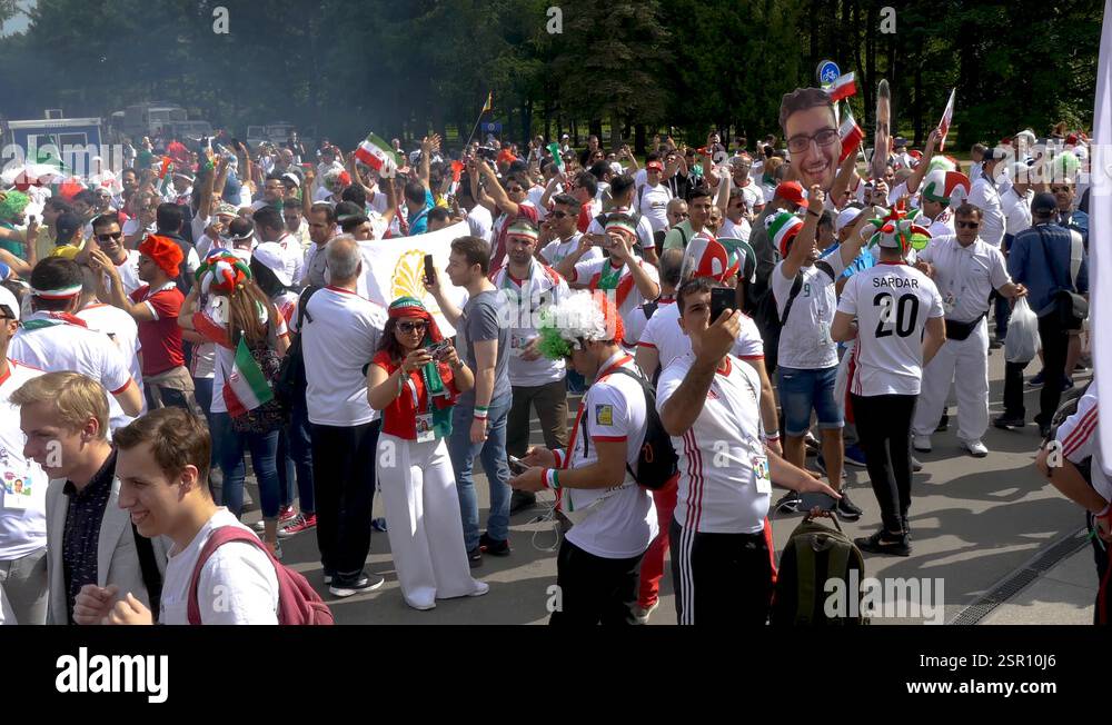 Iranian crowd of football fans in street waving flags chanting and ...