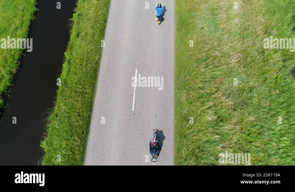 Aerial top down footage of two small motorcycles driving behind each ...