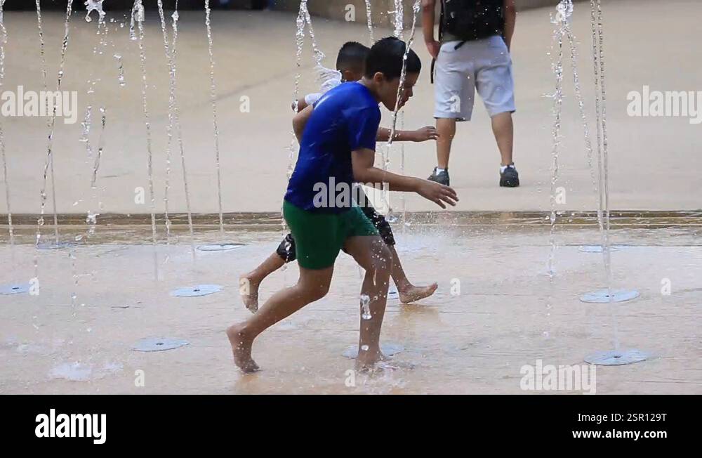 Children from colombian favelas bathing in a water fountain in a public ...