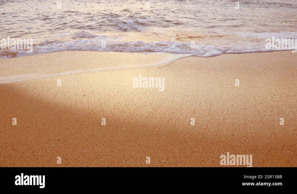 Texture of water and sand. Coast. Golden sand. Small waves break sandy ...