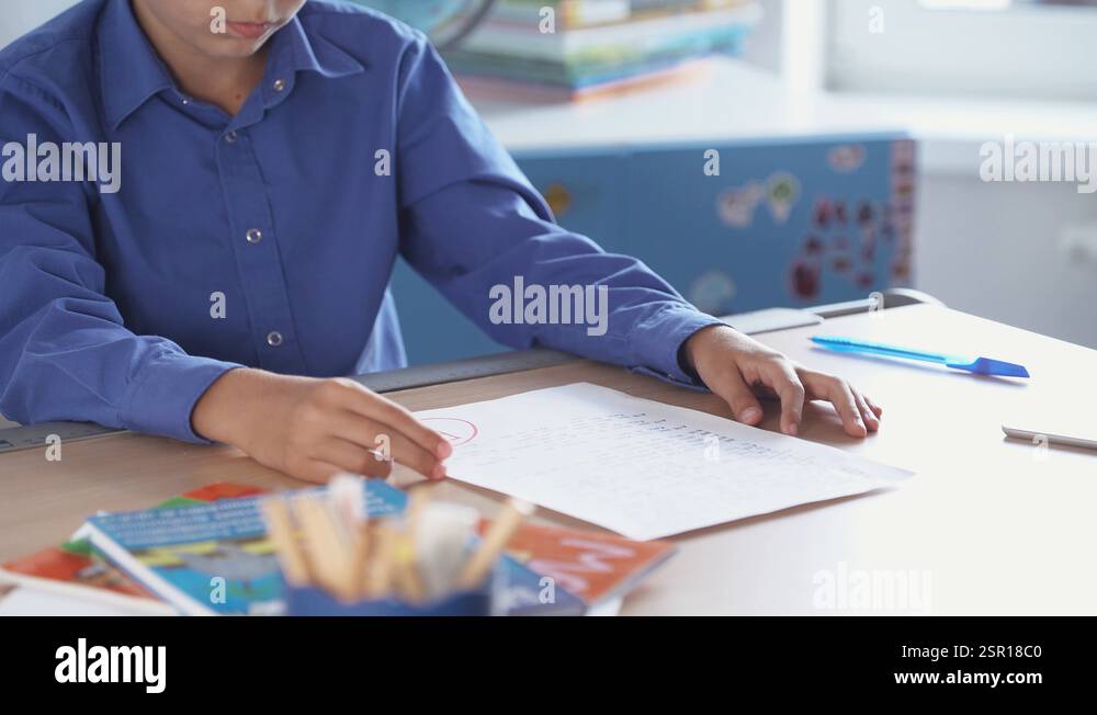 Schoolboy got a bad grade on test work, tears the paper in half, sad ...