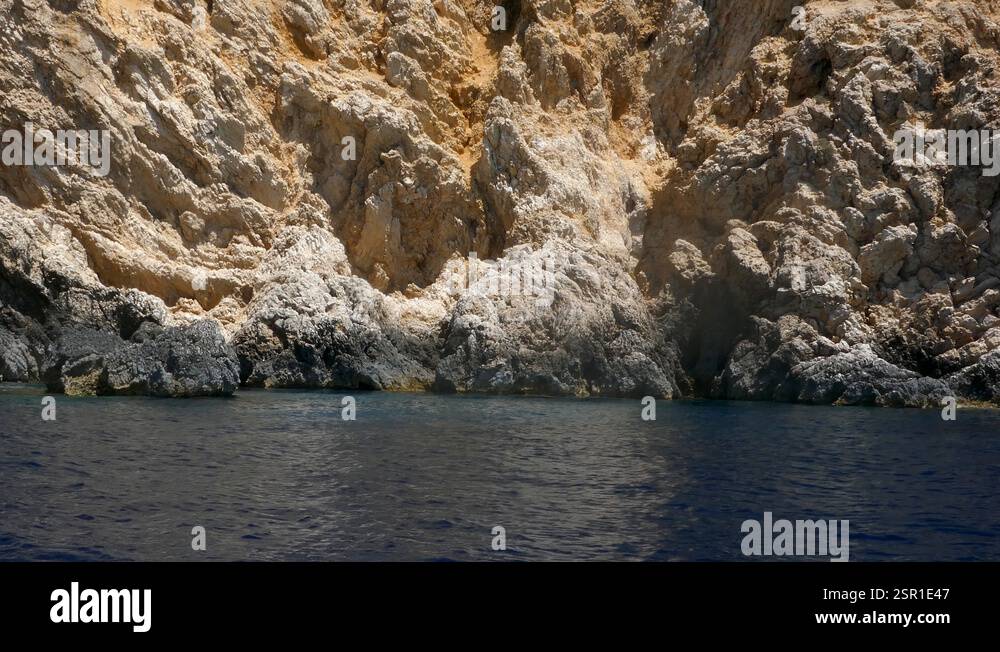 Crystal clear turquoise sea waters and sedimentary rocky cliff. camera ...