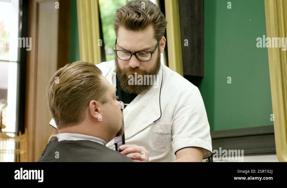 Shaving of beard. Barber cutting men's face hair with trimmer at ...