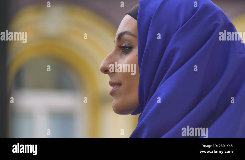 Profile of young beautiful muslim woman in blue hijab with pierced nose ...