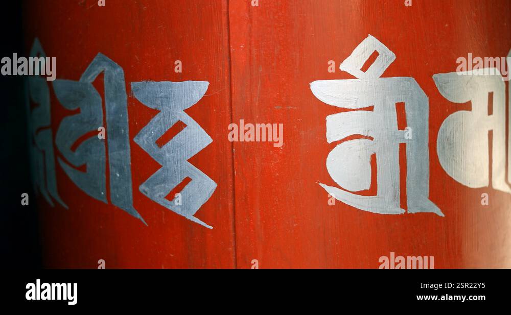 Buddhist mantra written on prayer wheel with decorated letters spinning ...