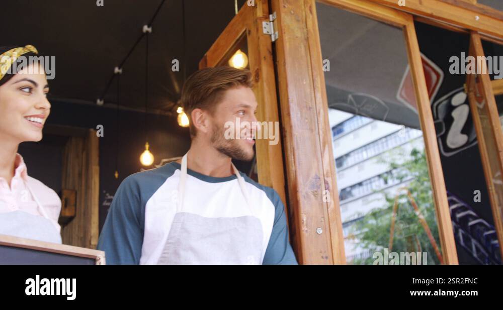 Male waiter and female waitress standing with open sign board 4k Stock ...