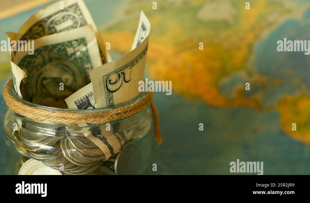 Travel budget concept. Money saved for vacation in glass jar on world ...