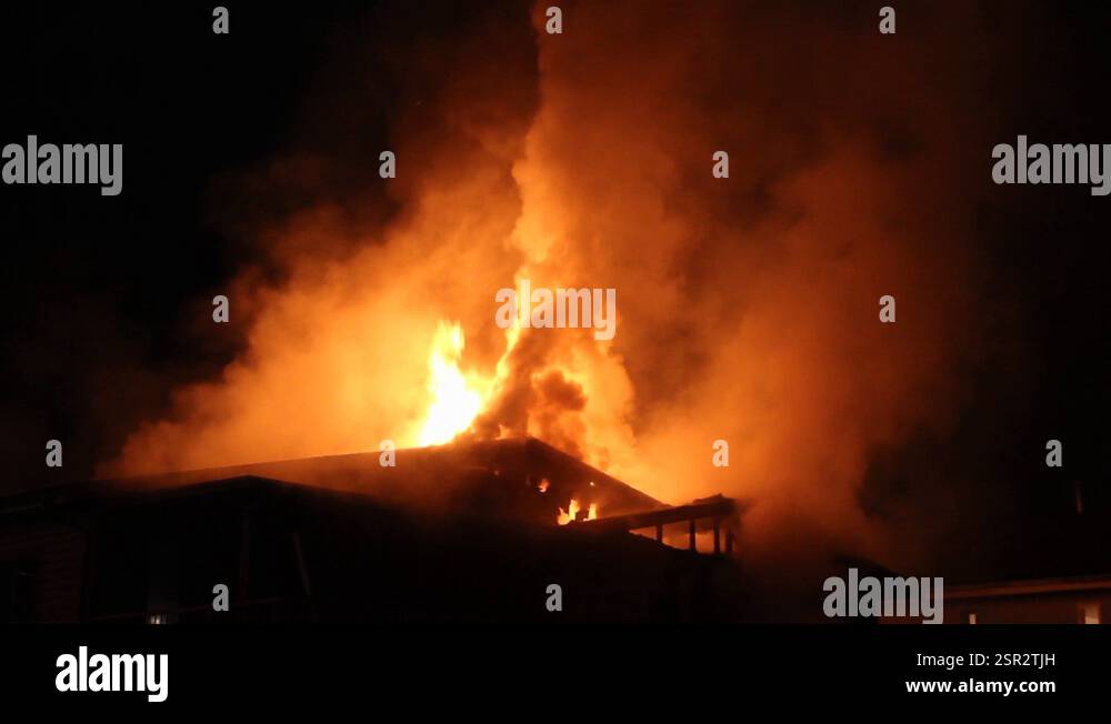 Flame ripping in middle of cloud of smoke during structure fire ...