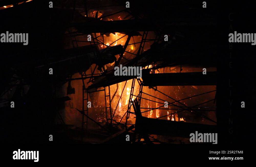 Scaffolding collapsing following a fire at night with reminiscent of ...