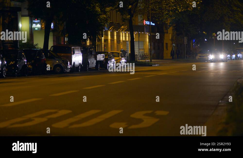 Man on bicycle, cars drive by, nighttime cityscape, Hamburg, Germany ...