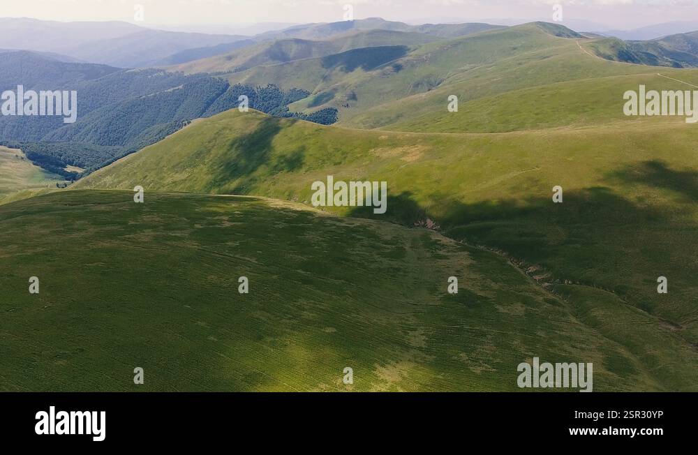 Aerial of horizonless ranges with curvy roads and cloud shades in ...