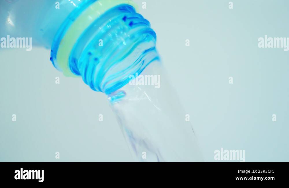 stream of clean transparent water is pouring out of a plastic bottle ...