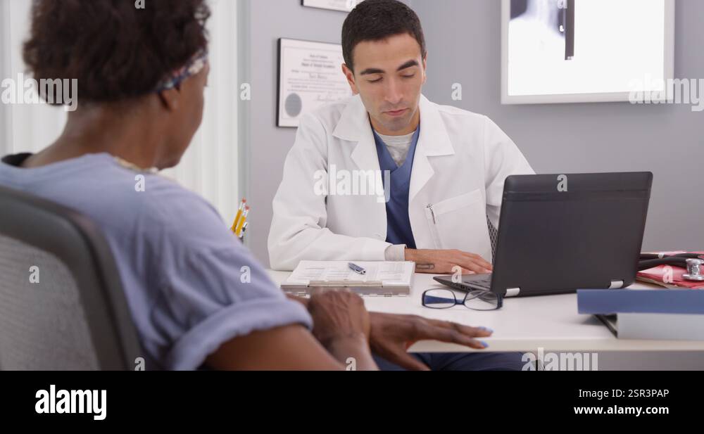 Young radiologist discussing with middle aged black woman her surgical ...