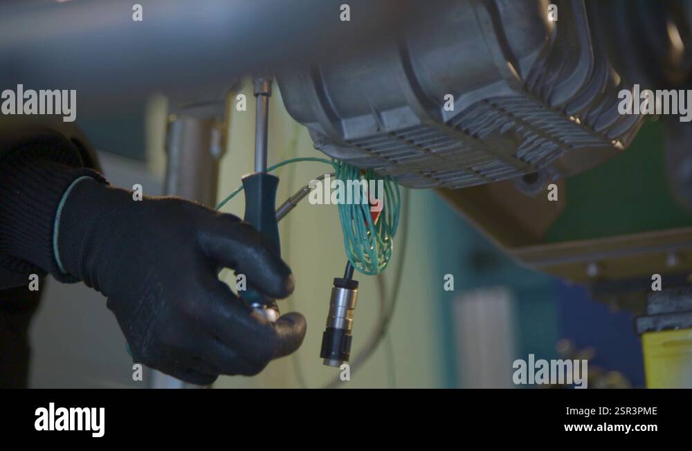 Hand of mechanic unscrews bolt of a car engine at service station. Slow ...