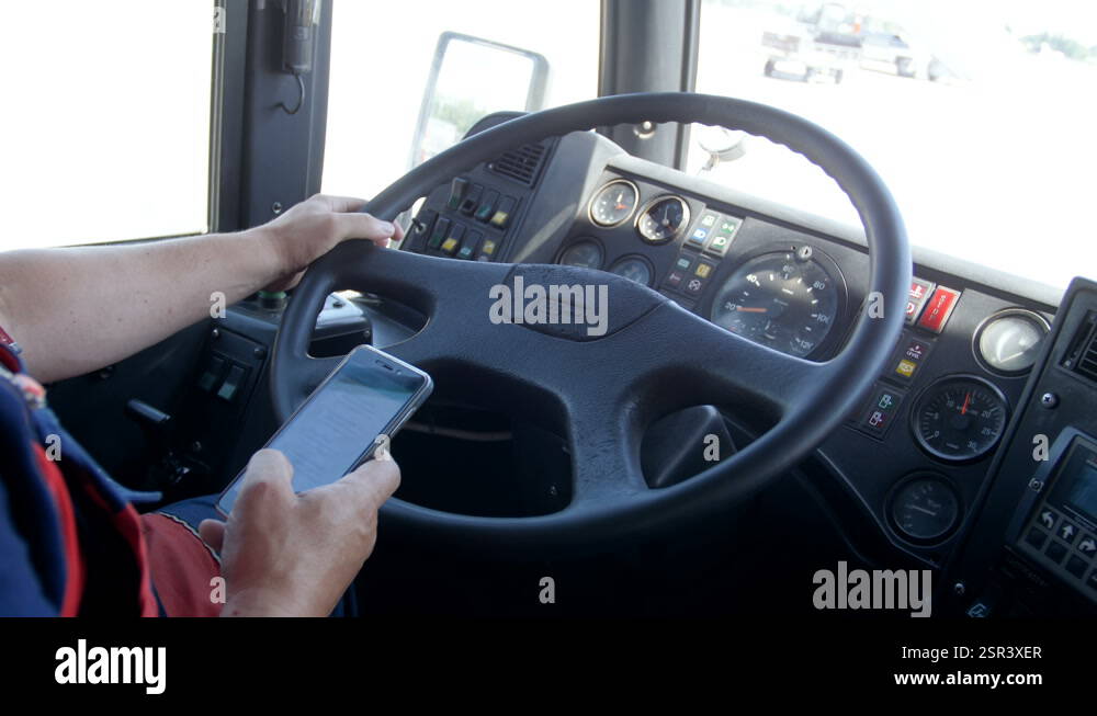 Closeup 4k footage of public bus driver typing message on smartphone ...