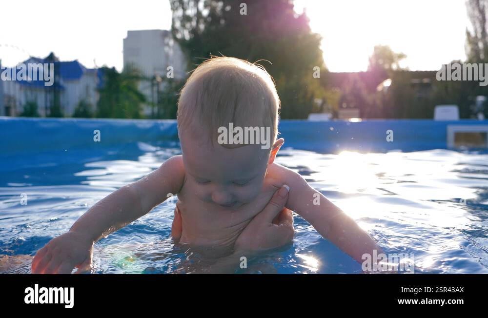 cute little boy in swimming pool, mom teaches a child to swim at summer ...