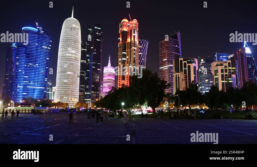 People in public square near skyscrapers in financial district in Doha ...