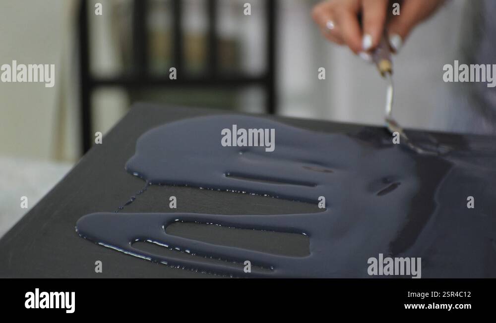 women in an art studio mix paints and draw on canvas in fluid art ...