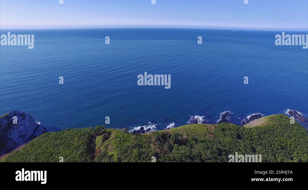 Flying above green cliff and view of coastline and great sea of Japan ...