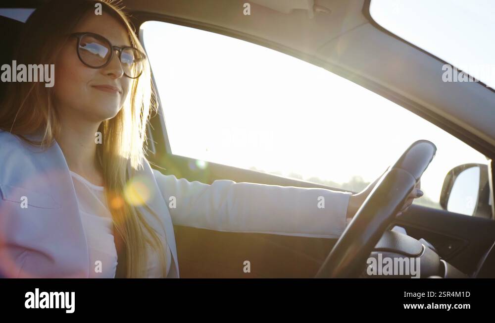 Woman driving car to work on sunny day Stock Video Footage - Alamy