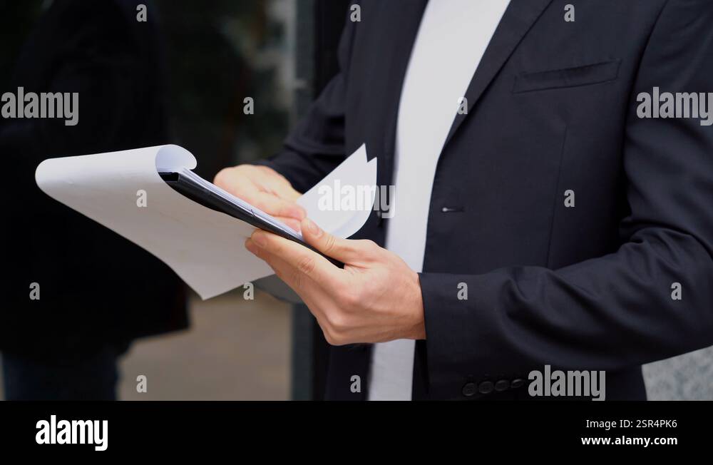 Hands of young man in suit jacket checking, reviewing documents ...